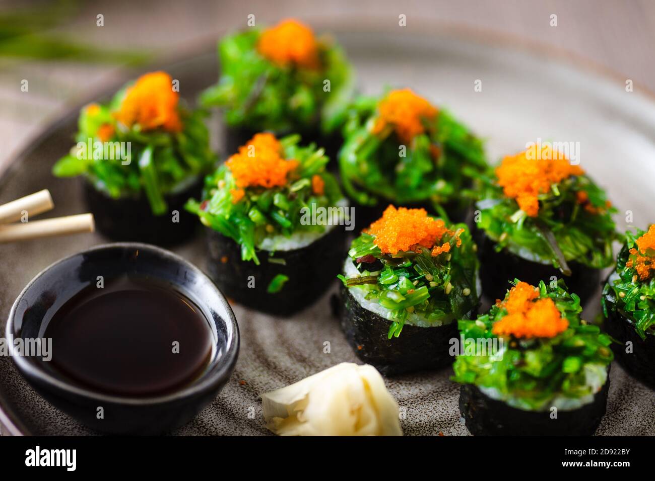 Sushi maki rolls with crab, seaweed salad and flying fish roe on a ...