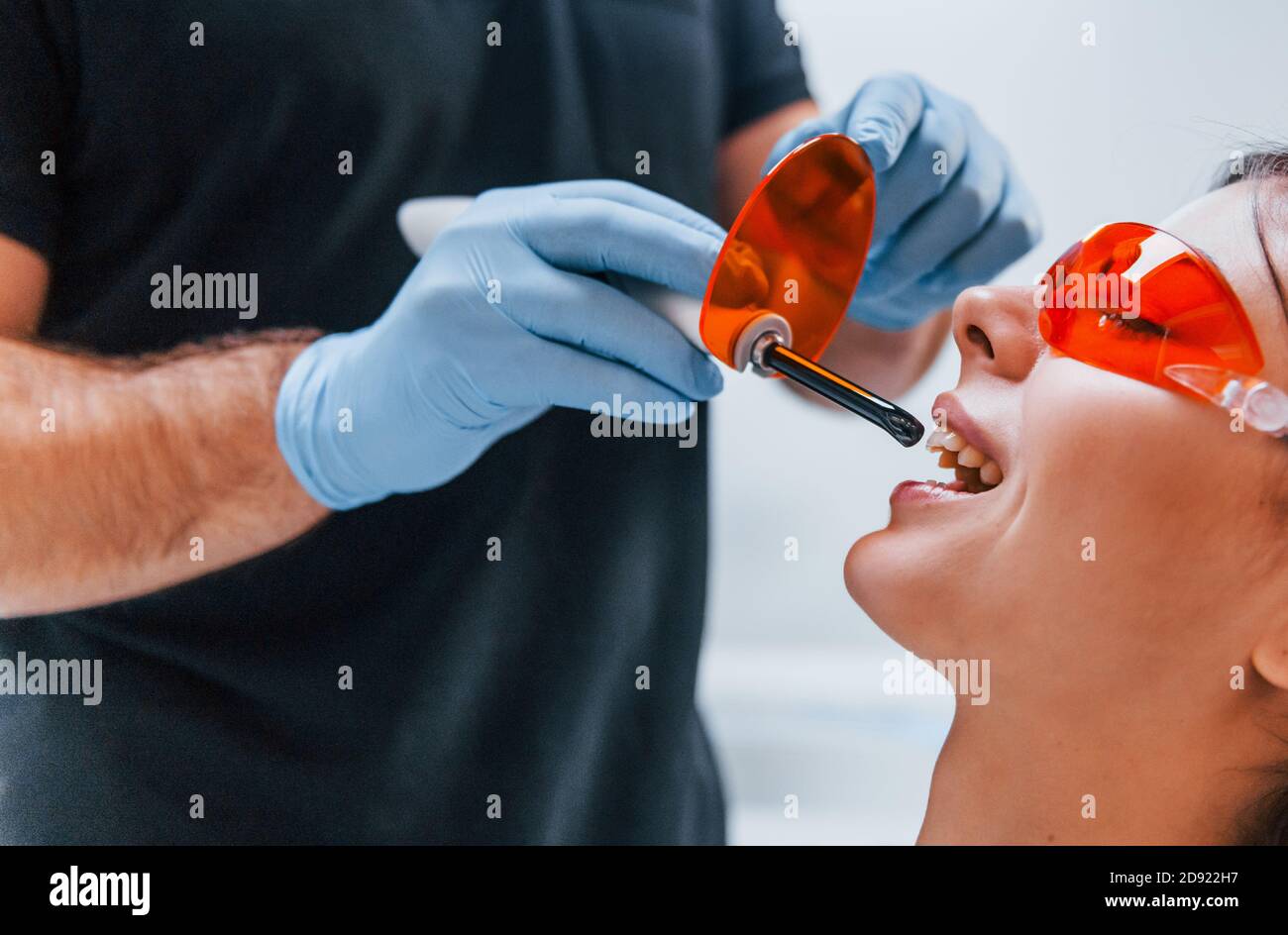 Beautiful woman in red protective glasses have a visit in the dentist ...