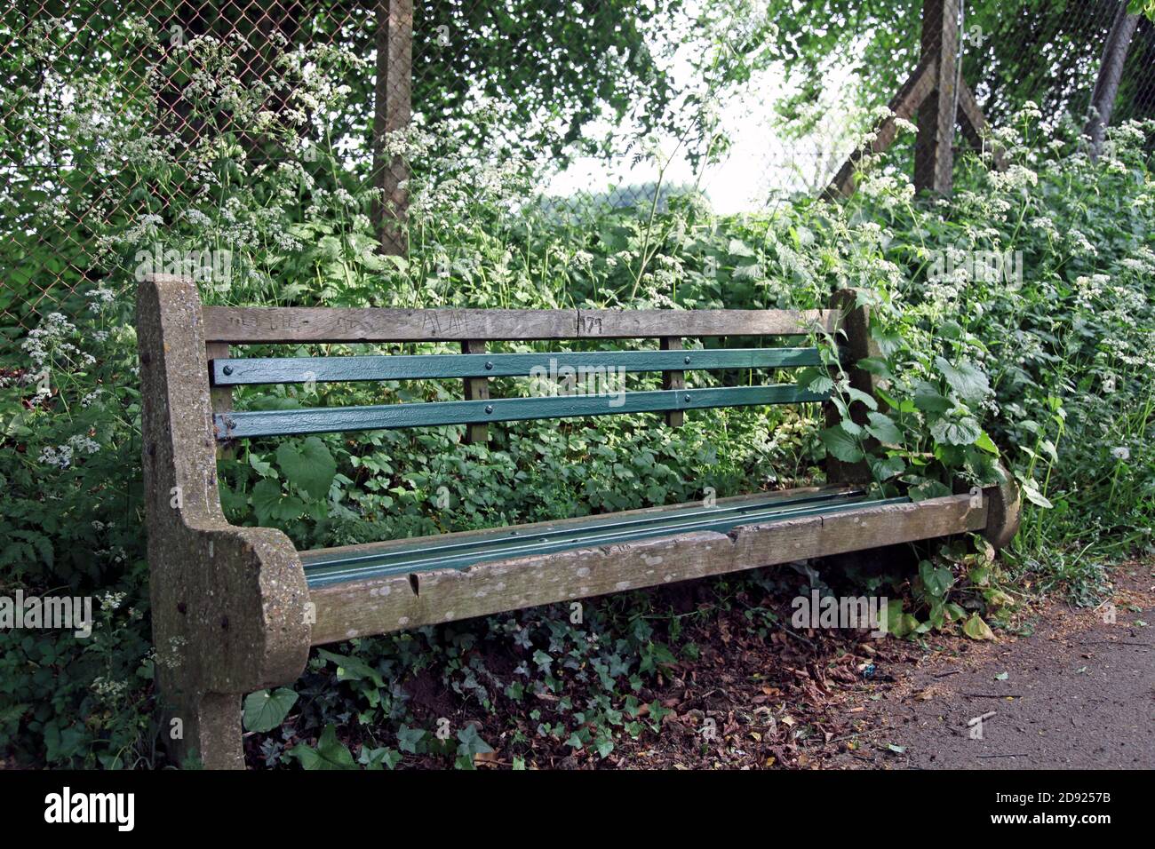Empty public concrete bench, with wooden and metal slats, on a path ...