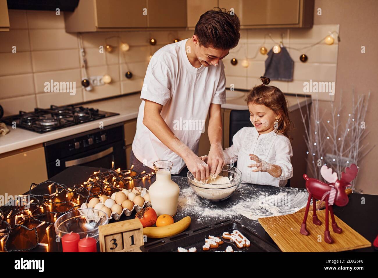 Brother with his little sister preparing food on kitchen and have fun ...