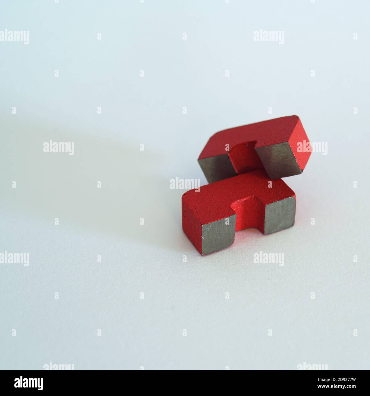 Red magnets on white paper background Stock Photo - Alamy