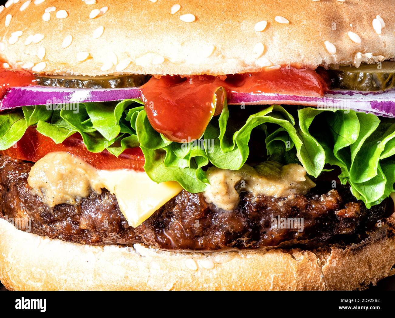 Macro shot of a cheeseburger consisting of a bun with sesame seeds ...