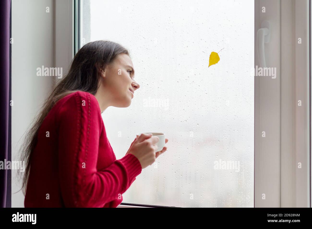 Woman looking through window rain hi-res stock photography and images ...