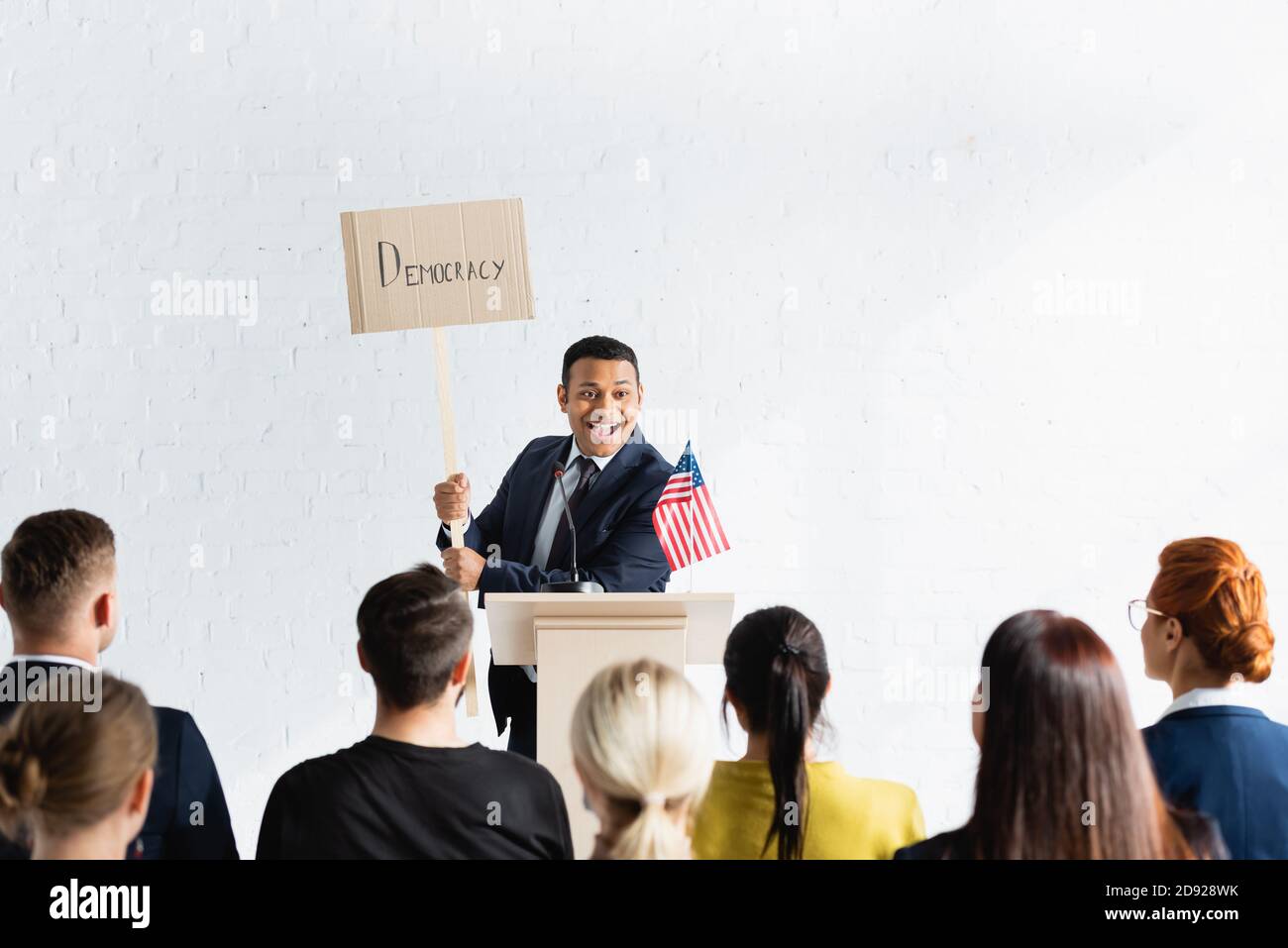 excited indian speaker holding placard with democracy inscription in ...