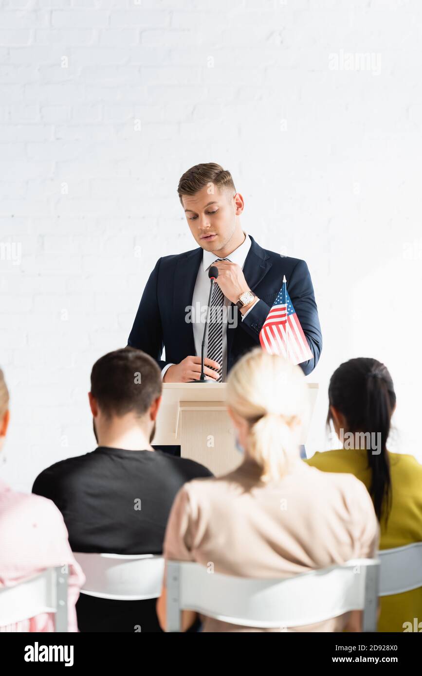 confident political agitator standing in front of voters in conference ...
