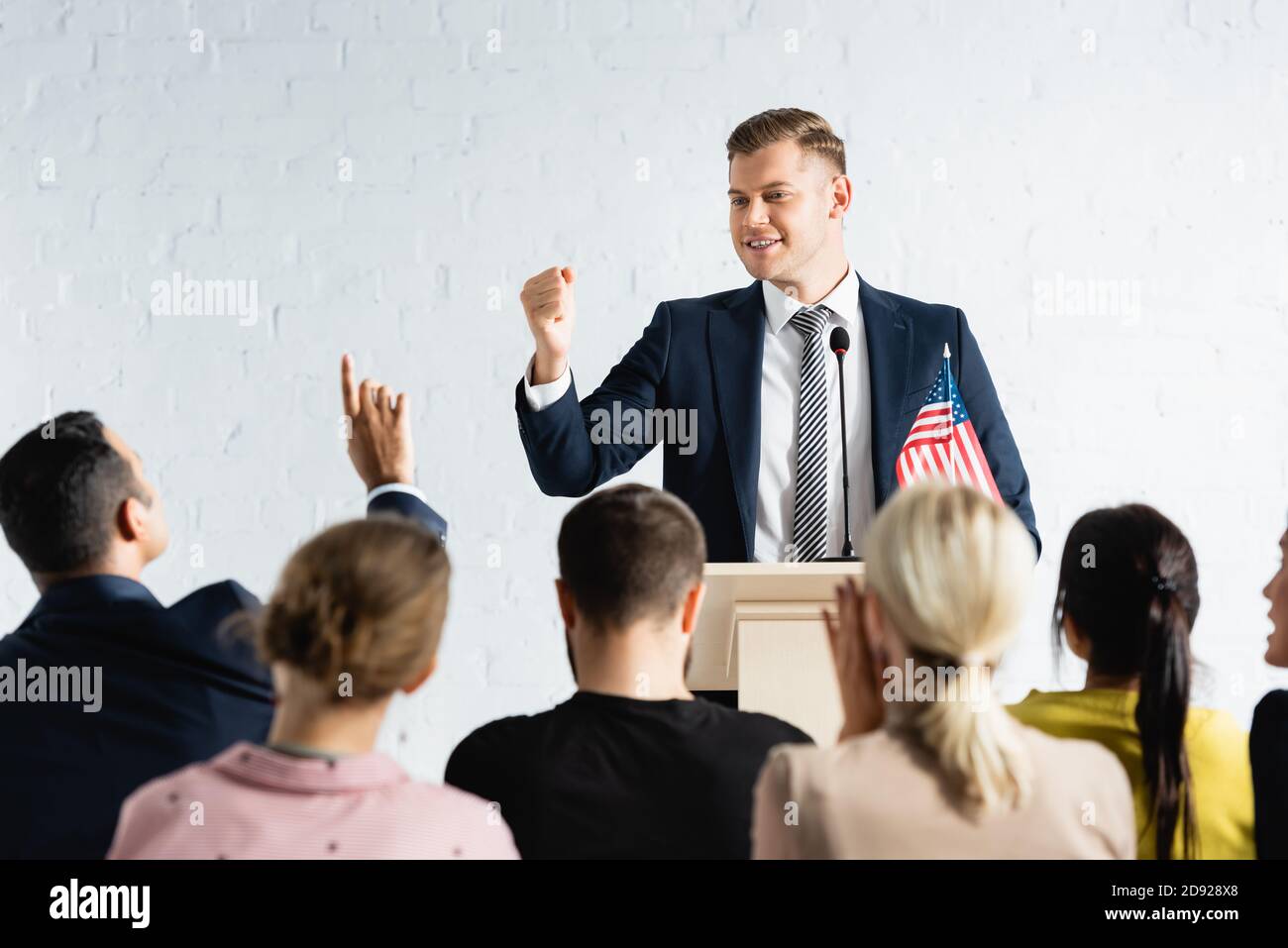 smiling political agitator showing win gesture in front of voters in ...