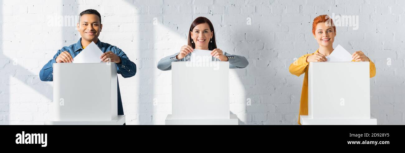 multicultural electors inserting ballots into polling booths, banner ...