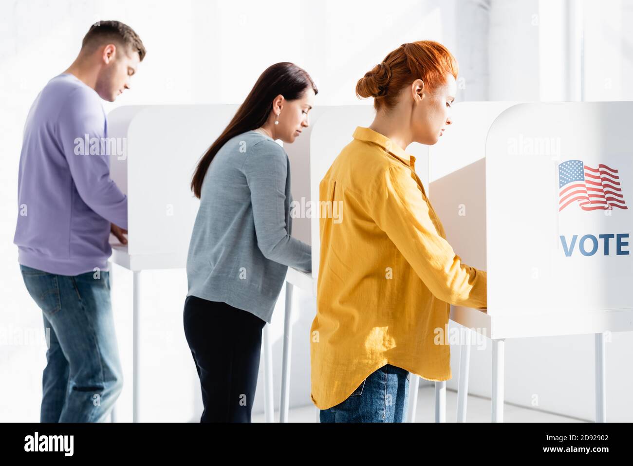 electors in polling booths with american flag and vote lettering on ...