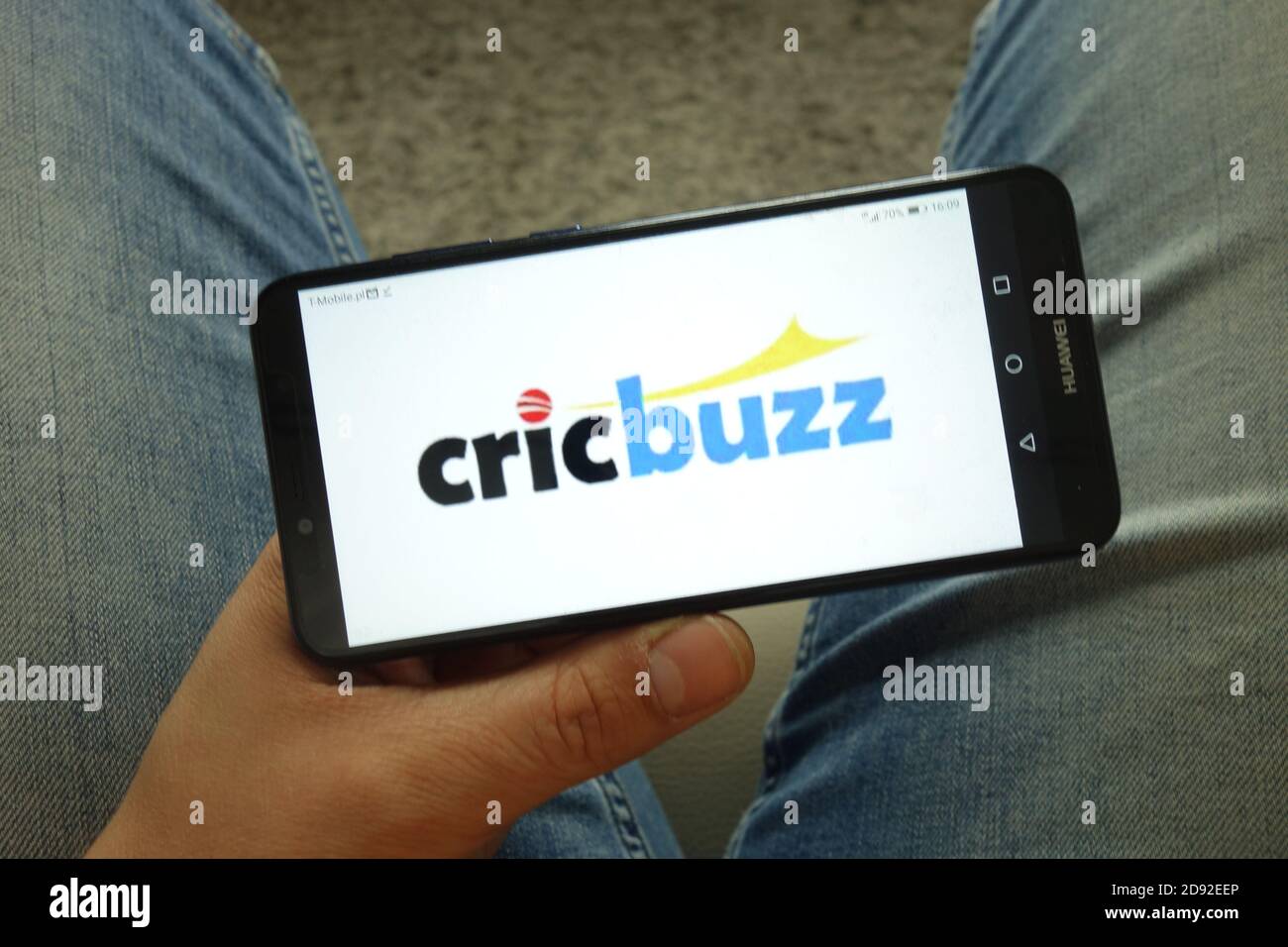 Man holding smartphone with CricBuzz website logo Stock Photo - Alamy