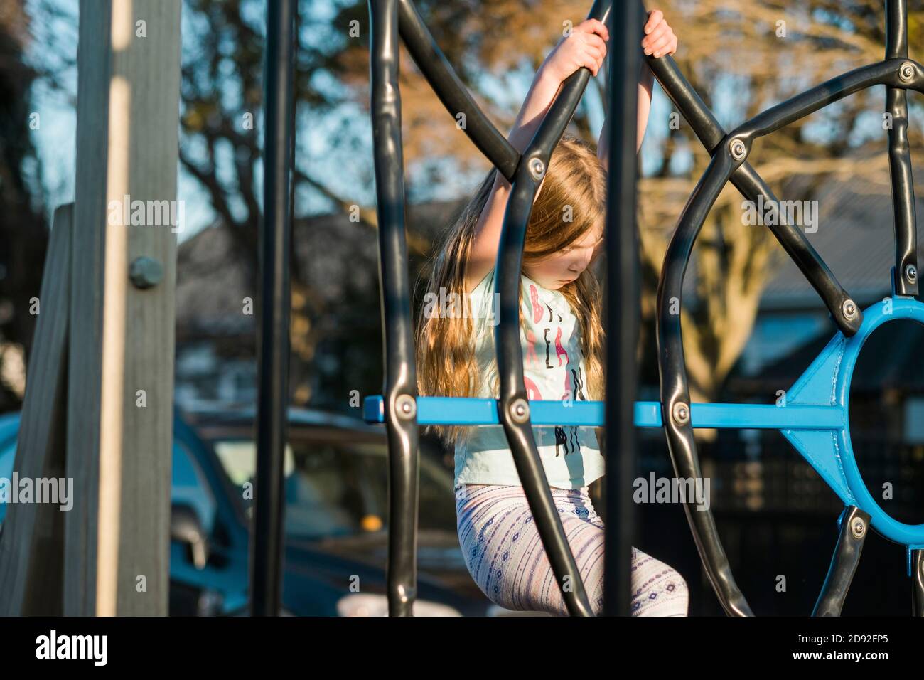 Young girl climbing and playing on playground equipment Stock Photo - Alamy