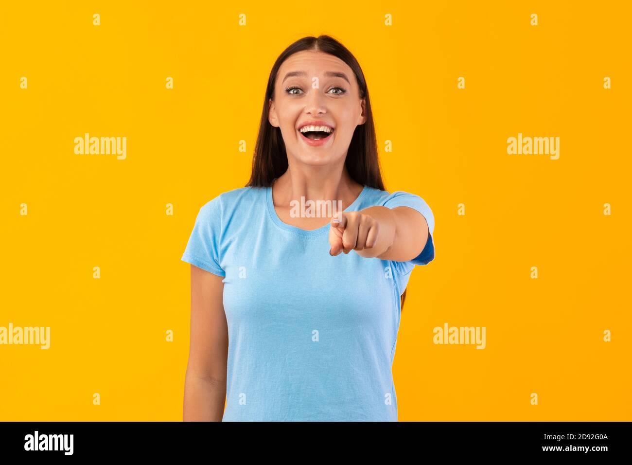 Happy lady pointing finger at camera at studio Stock Photo - Alamy