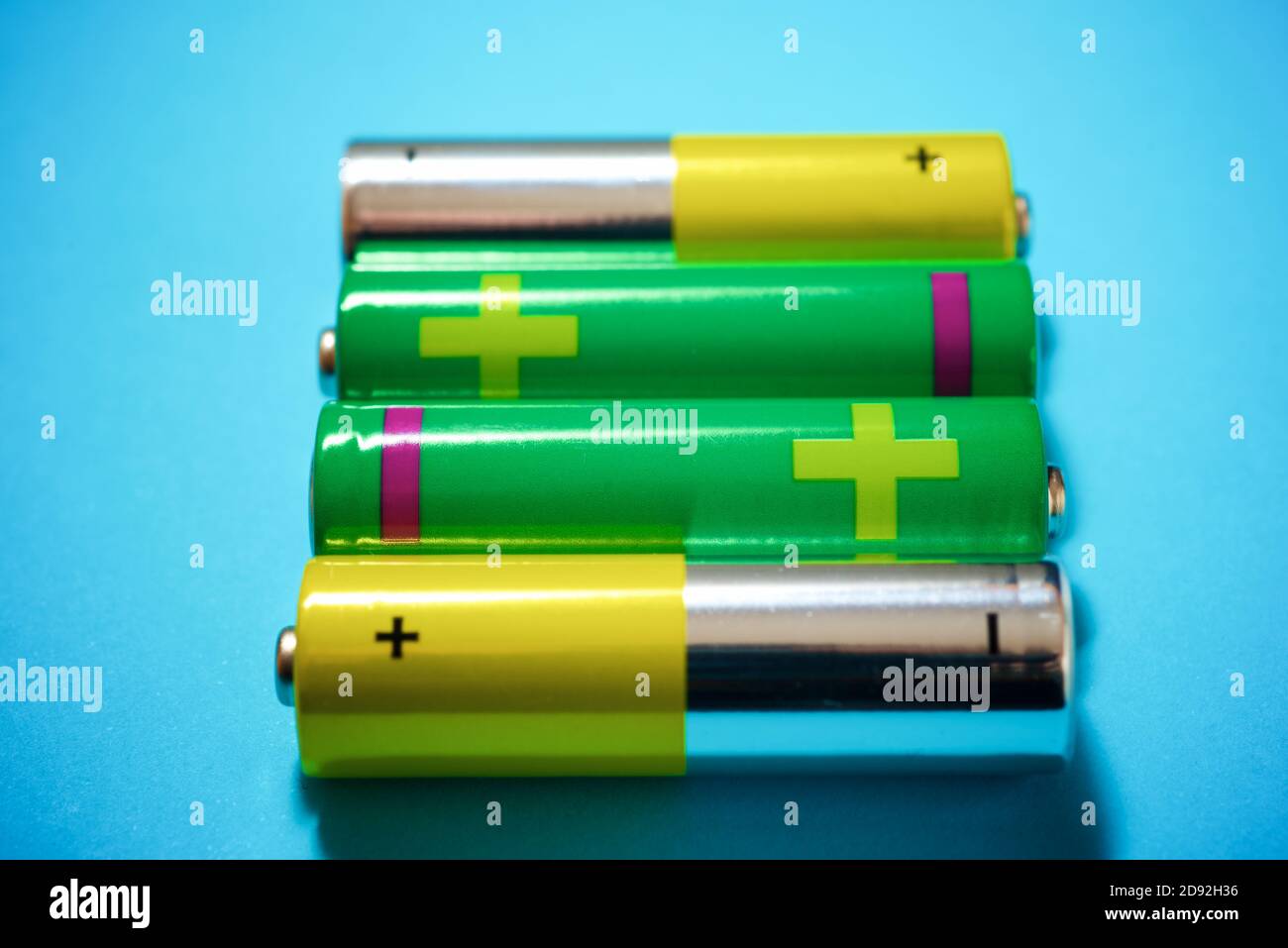 Small batteries on a blue table Stock Photo - Alamy