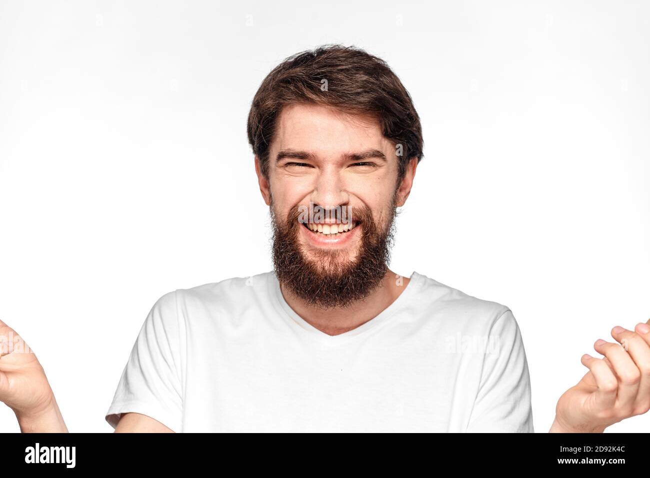 cheerful emotional bearded man gesturing with his hands close-up light ...