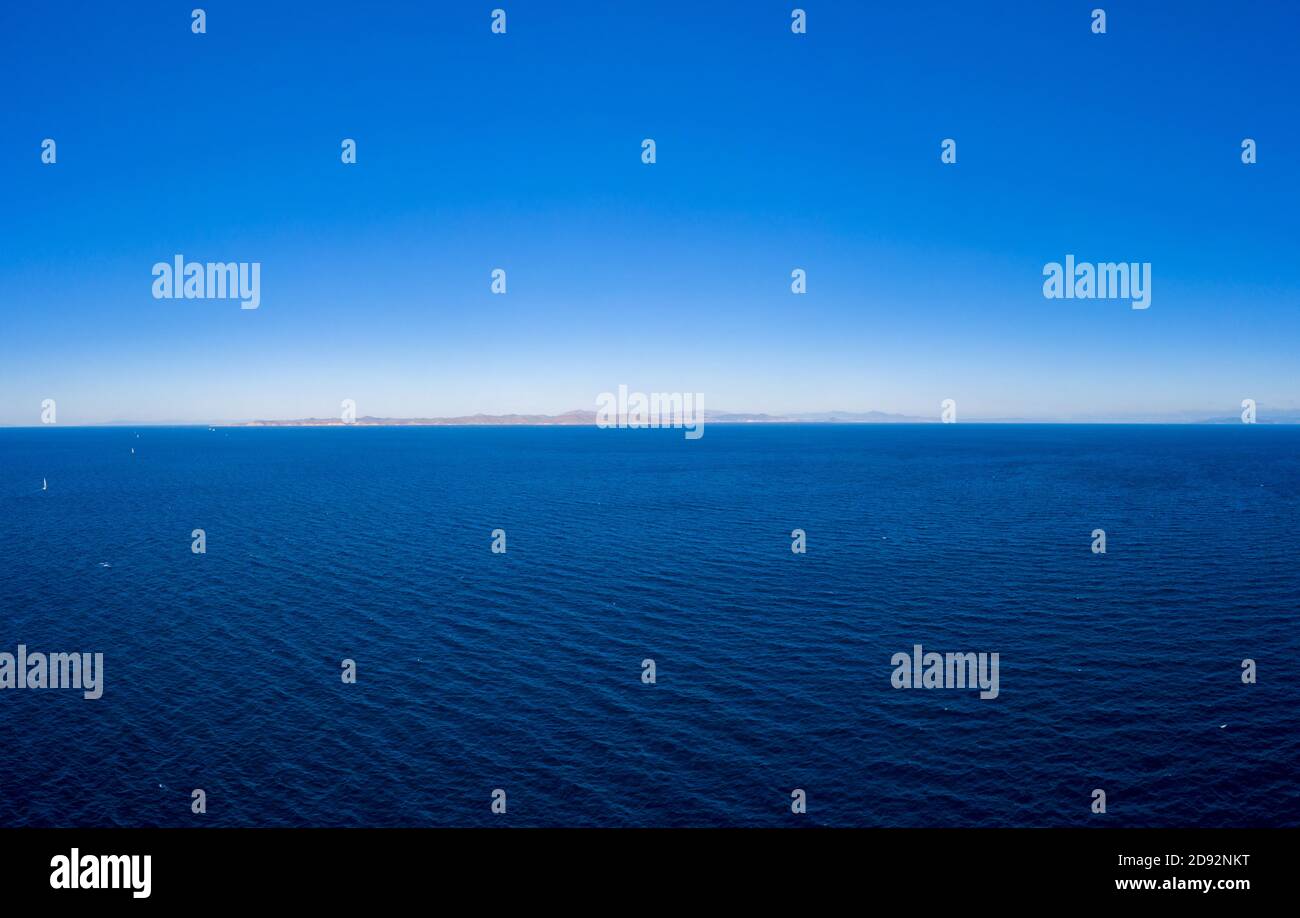 Clear empty Greek blue sky over the water and the mountains background ...