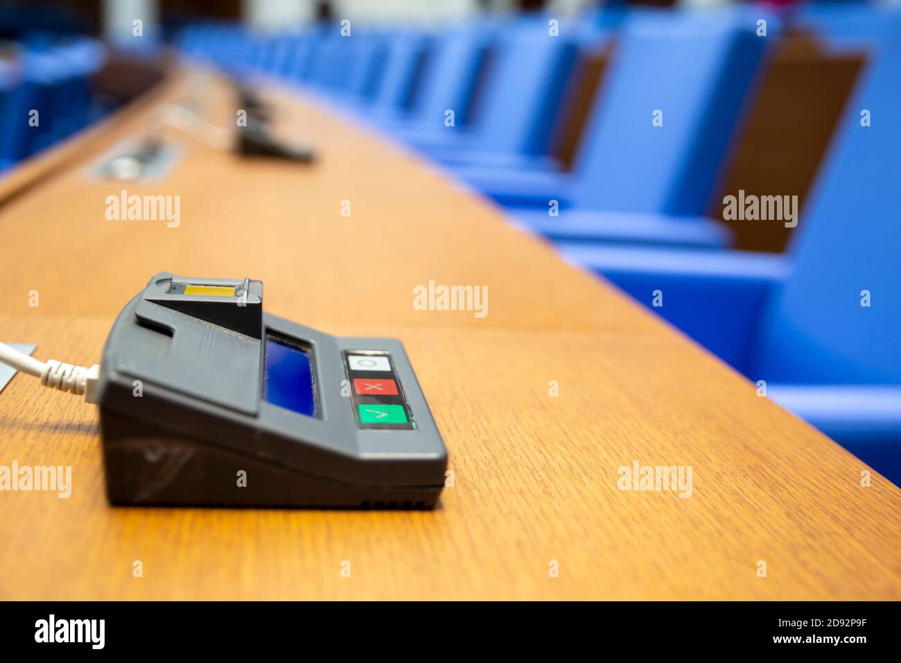Inside of an empty parliament hall. Blue chairs in line with voting ...