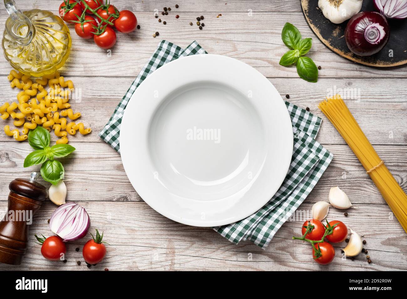 Food cooking background with vegetables, pasta and empty white plate ...