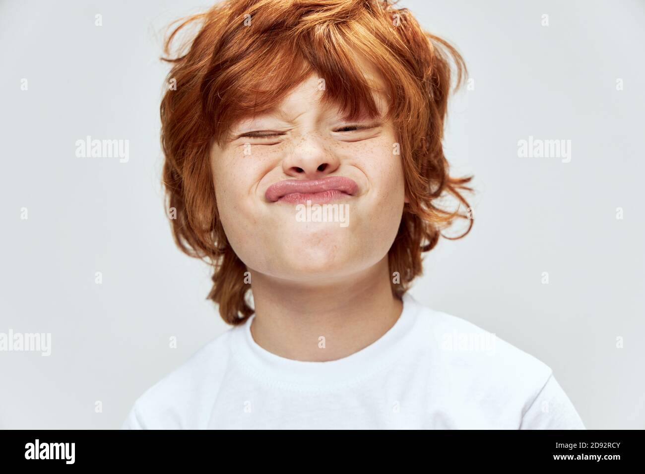 Redhead boy grimaces squinting eyes close-up white t-shirt Stock Photo ...