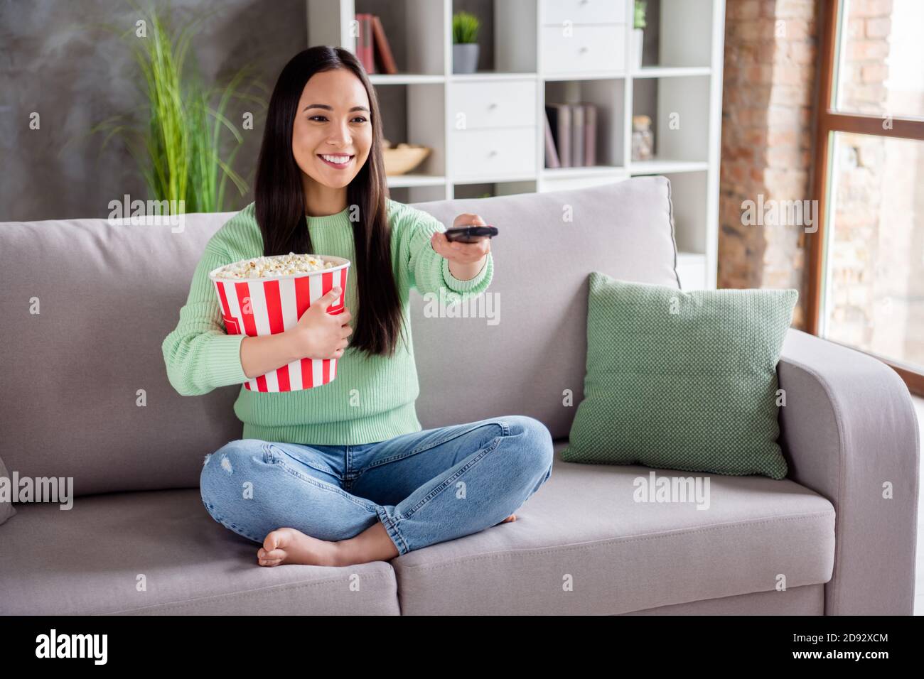 Full length photo of positive cheerful korean girl sit divan legs ...