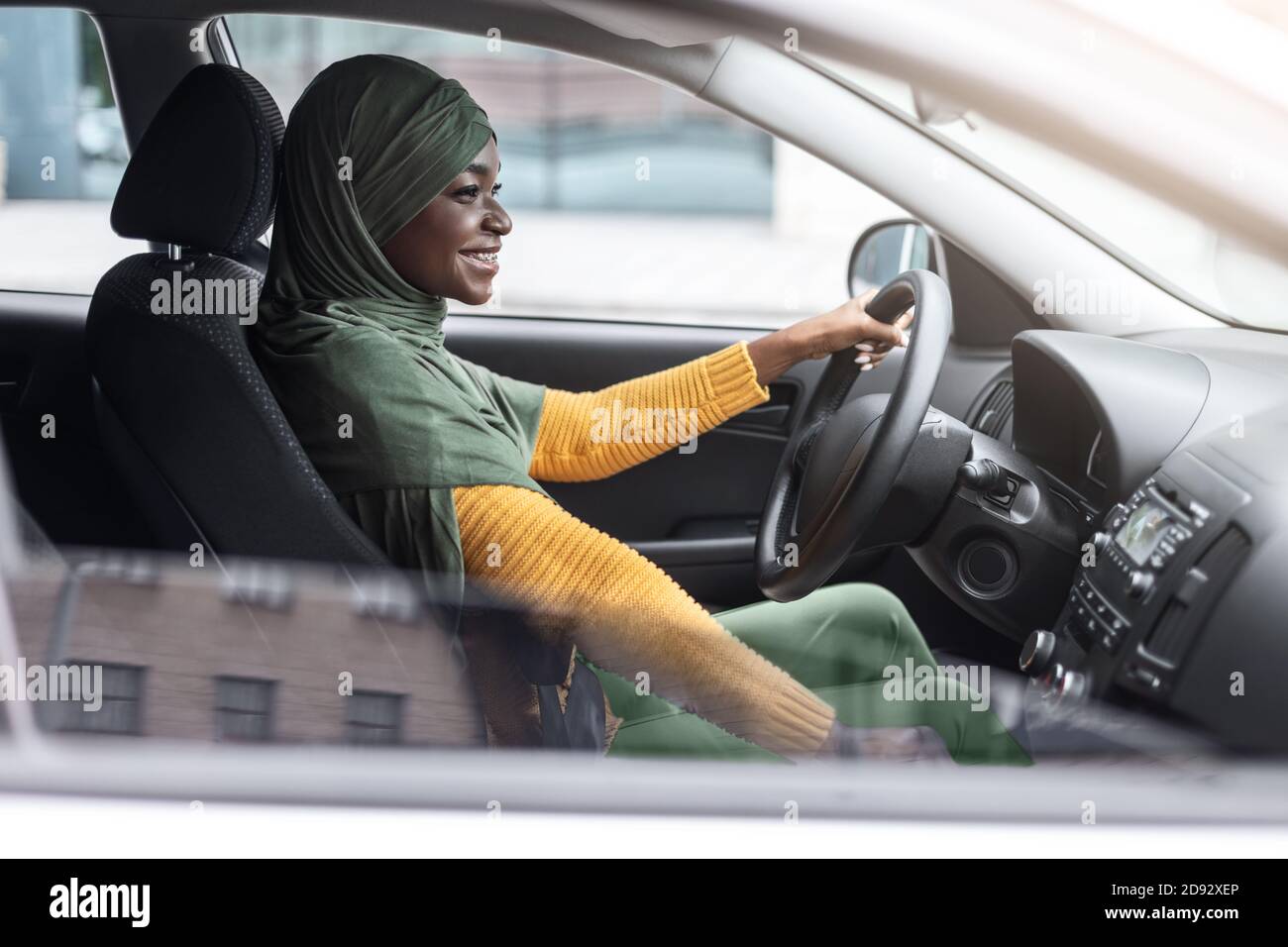 Confident Black Muslim Female In Hijab Enjoying Driving Car In City ...