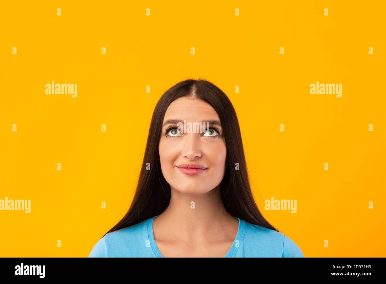 Portrait of smiling lady looking up at copy space Stock Photo - Alamy