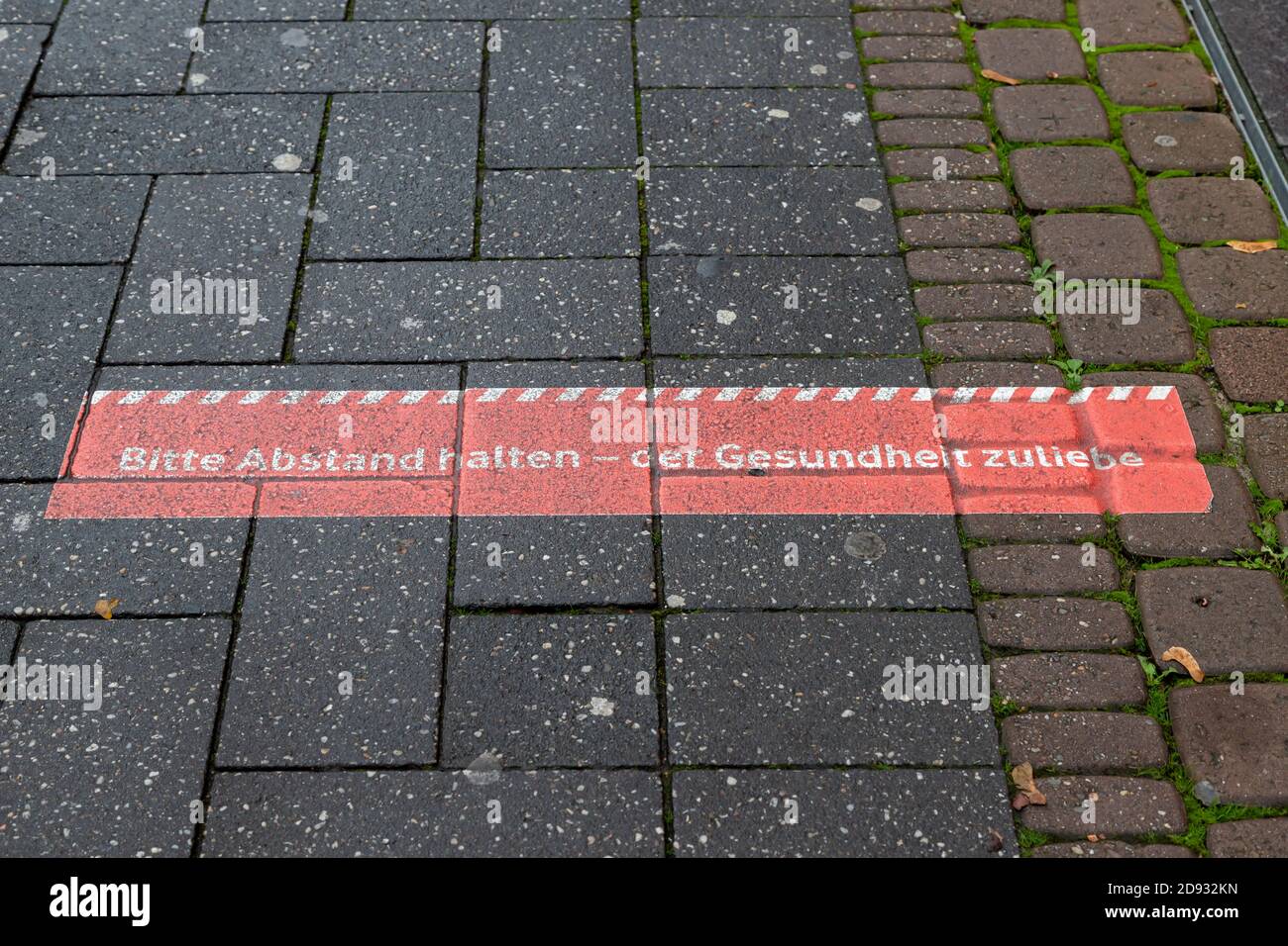 floor sign with advice to keep distance in german letters- Please keep ...