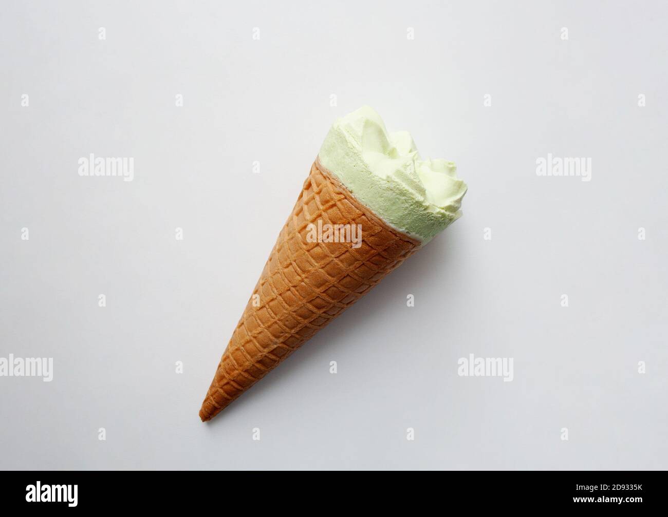 Pistachio flavored ice cream cone isolated on white background from a ...