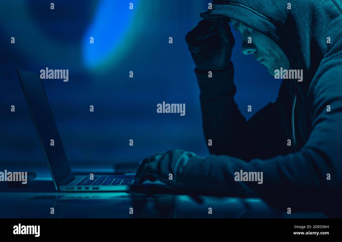 Hacker Wearing Black Hood in Front of His Laptop Computer Preparing For ...