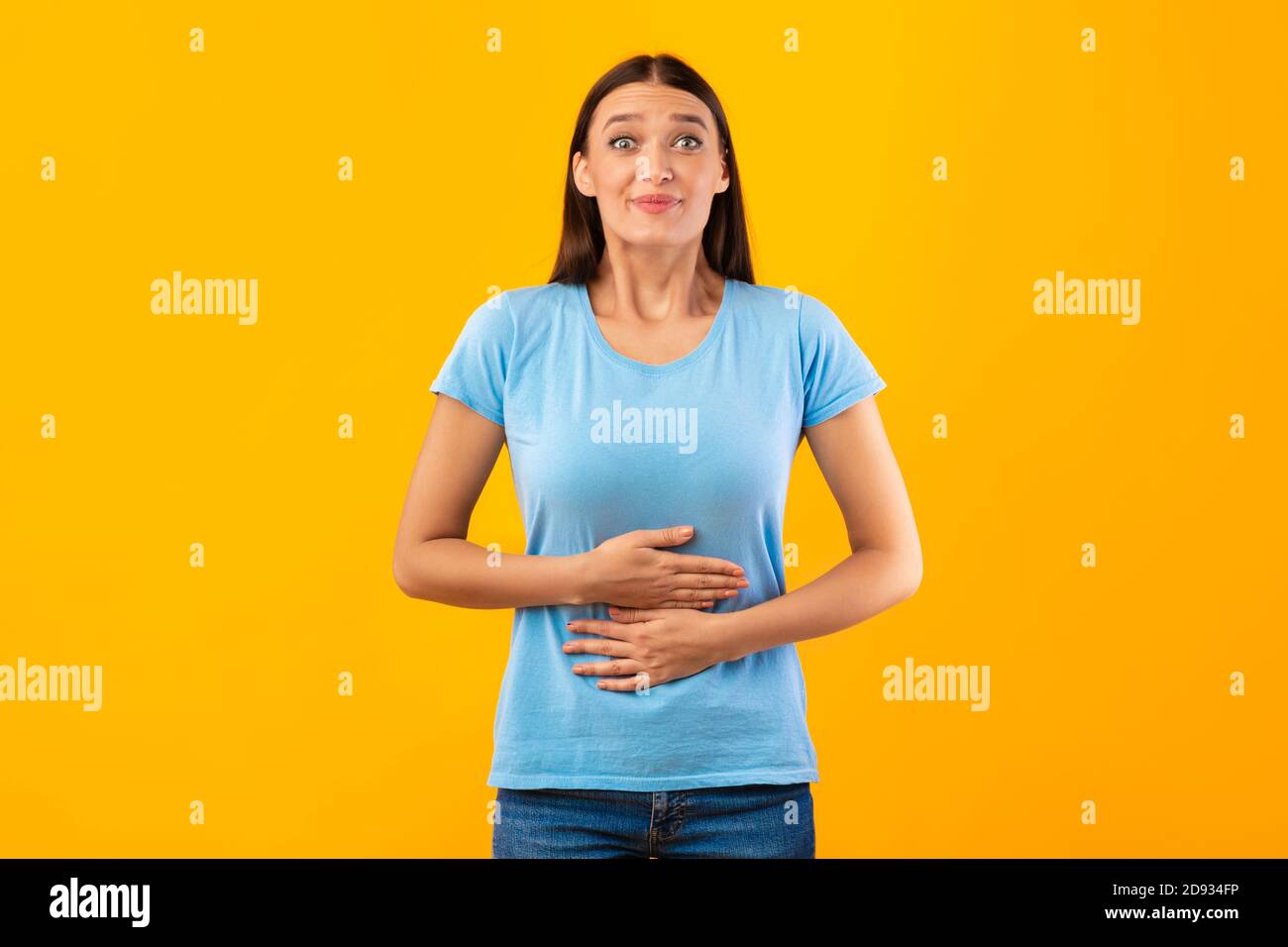 Young satisfied woman touching her stomach at studio Stock Photo - Alamy