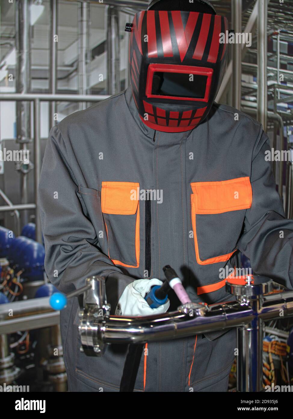 the welder in the workplace. the welder welds the pipe with argon ...