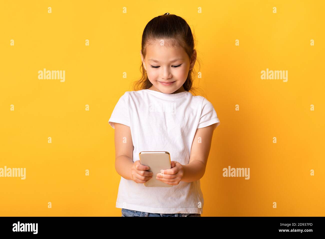 Happy girl using her mobile phone at studio Stock Photo - Alamy