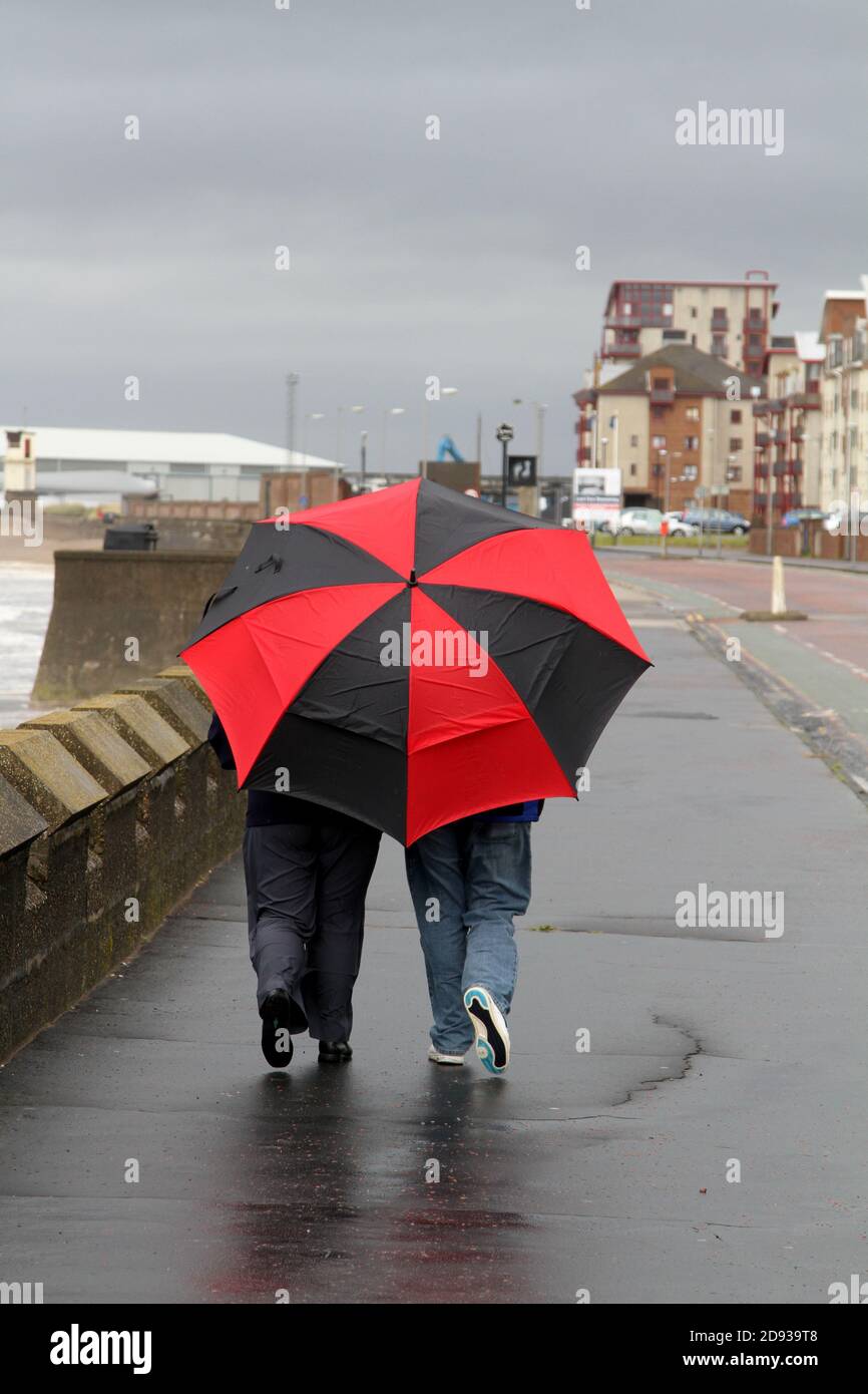 People Sharing An Umbrella