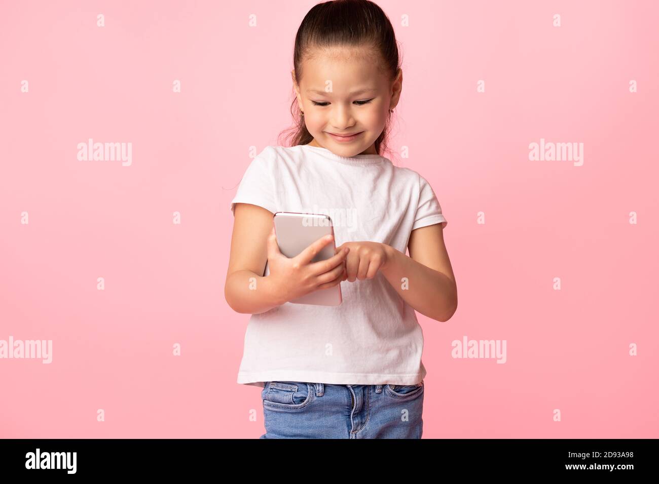 Happy girl using her smartphone at studio Stock Photo - Alamy