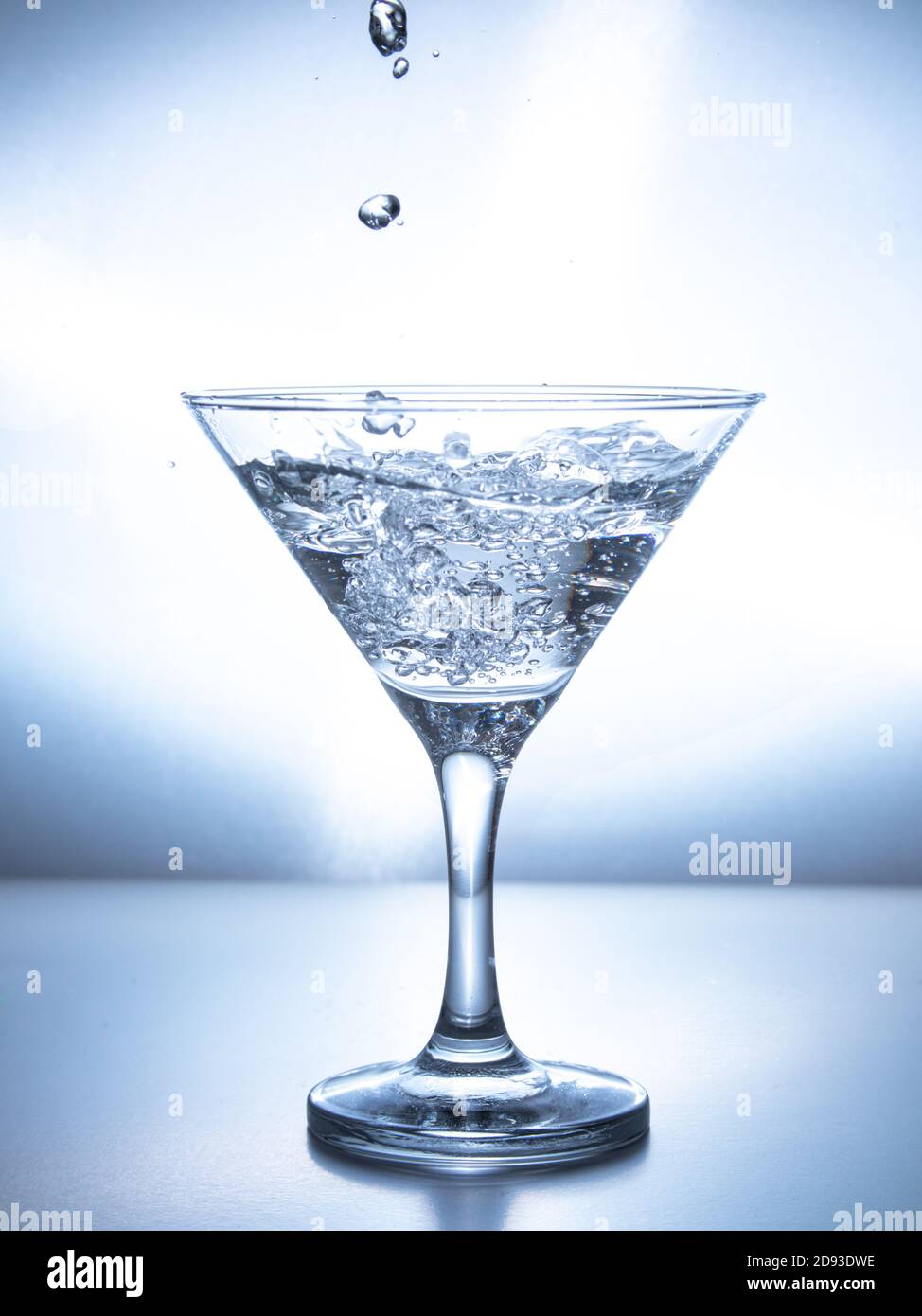 one glass of water with spray from falling water jet, white background ...