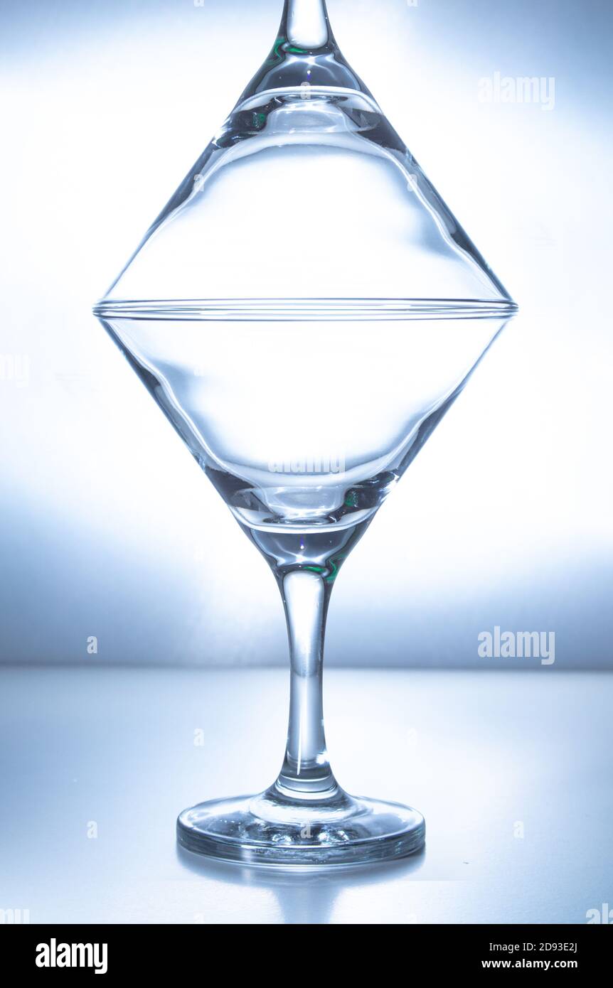 two empty glasses stand on top of each other on a white background ...