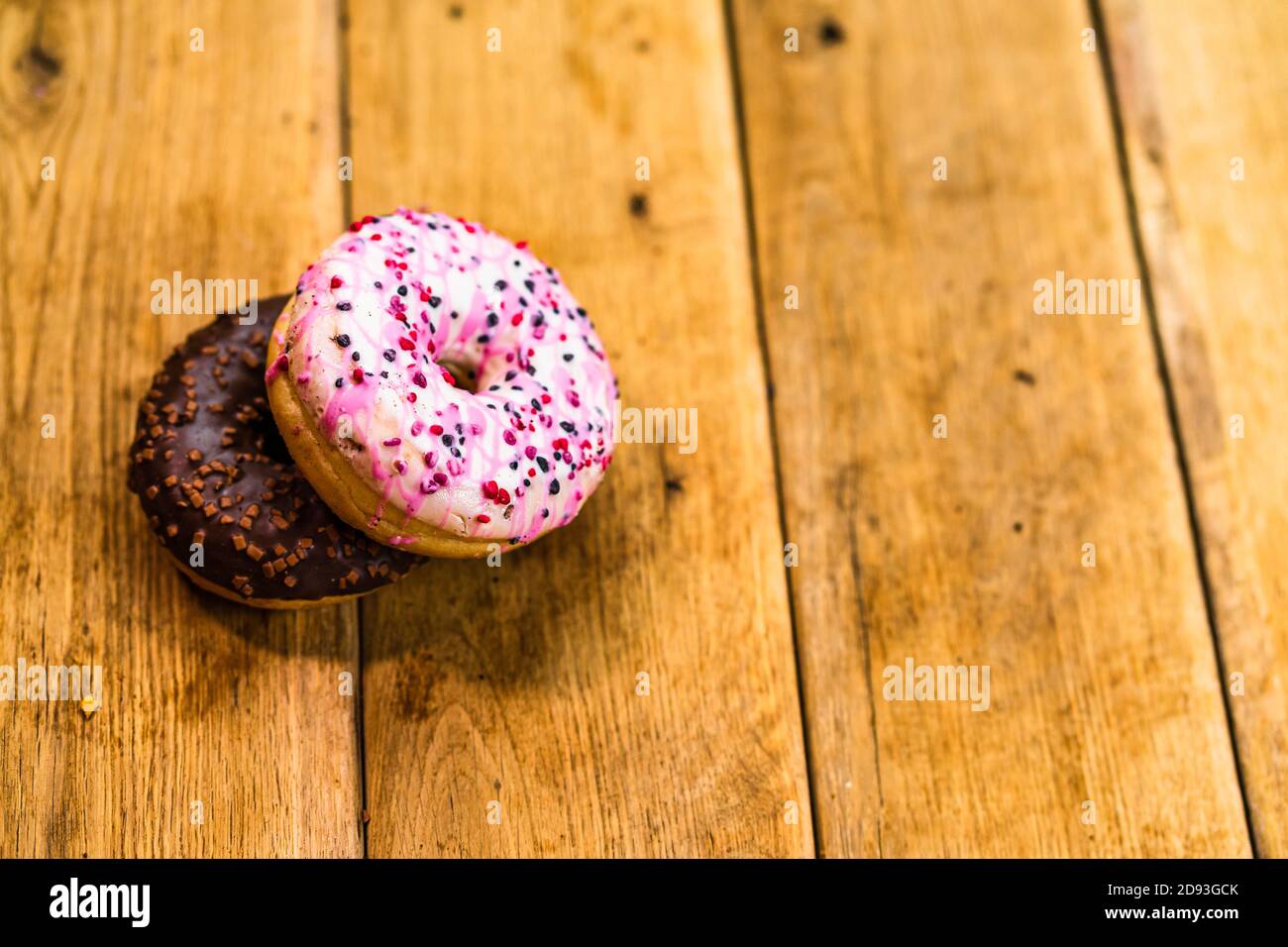 Colorful donuts on wooden table. Sweet icing sugar food with glazed ...