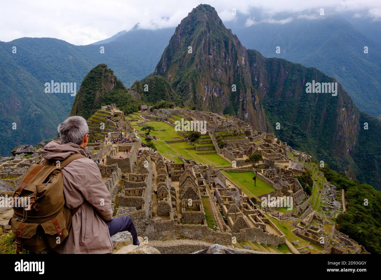 tourist sitting on his back watching Machu Picchu Lost City of Inca, Peru. One of the New Seven ...