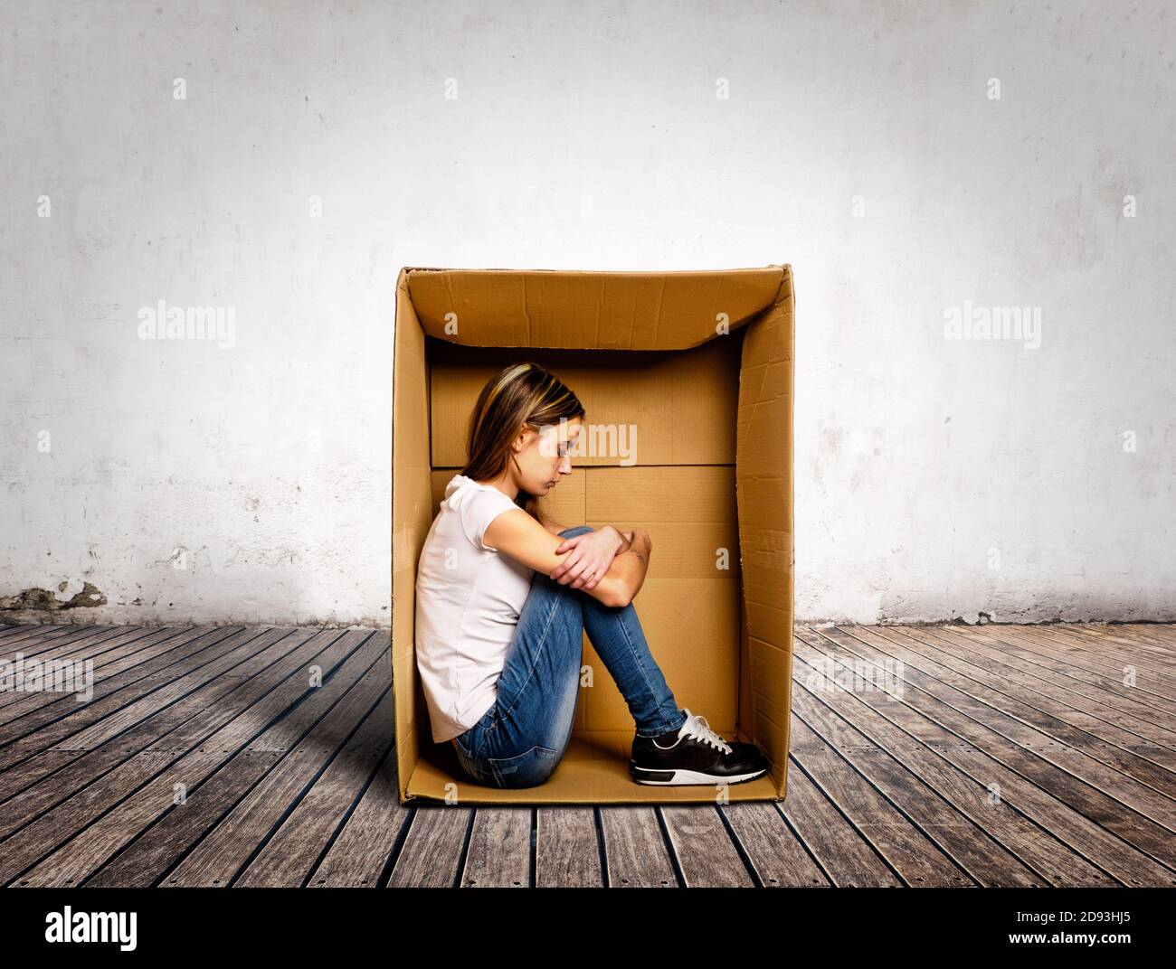 sad young woman inside a Box on a room Stock Photo - Alamy