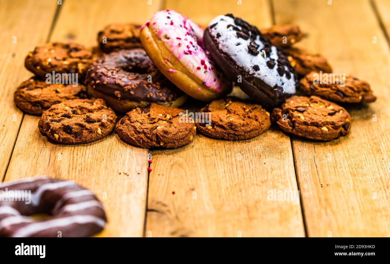 Colorful donuts on wooden table. Sweet icing sugar food with glazed ...