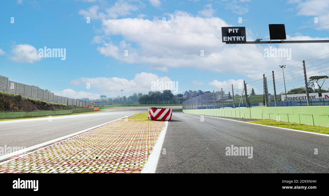 Separation obstacle warning and pit lane entry text board on asphalt ...