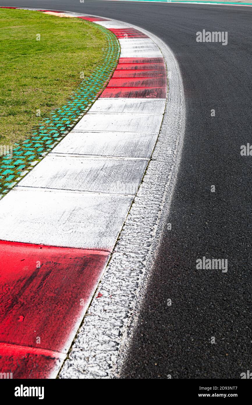 Close up of rough curb at left turn on motor sport track with green ...