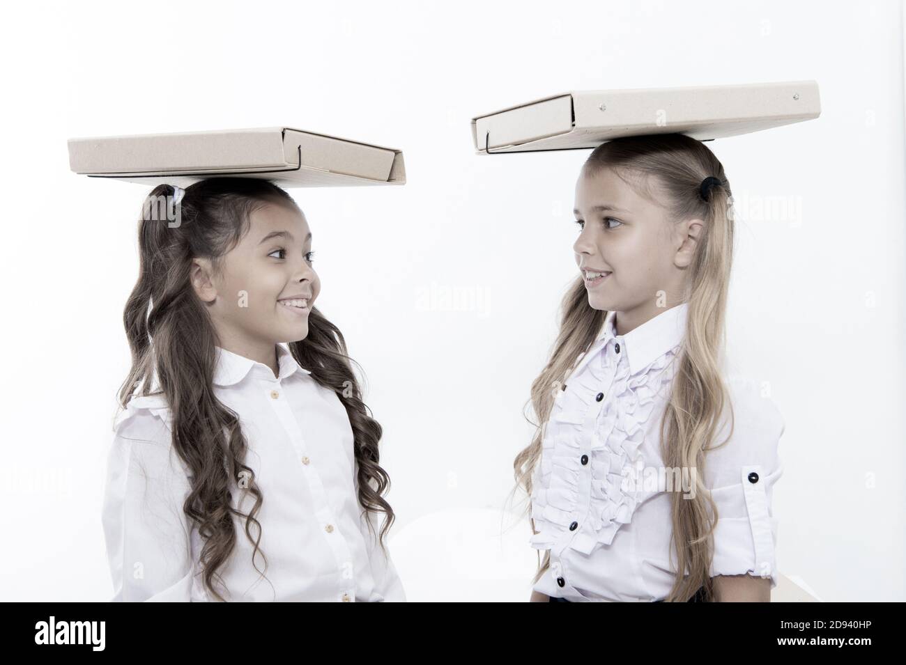 Find balance. Schoolgirls with cute pony tails hairstyle carry folders ...