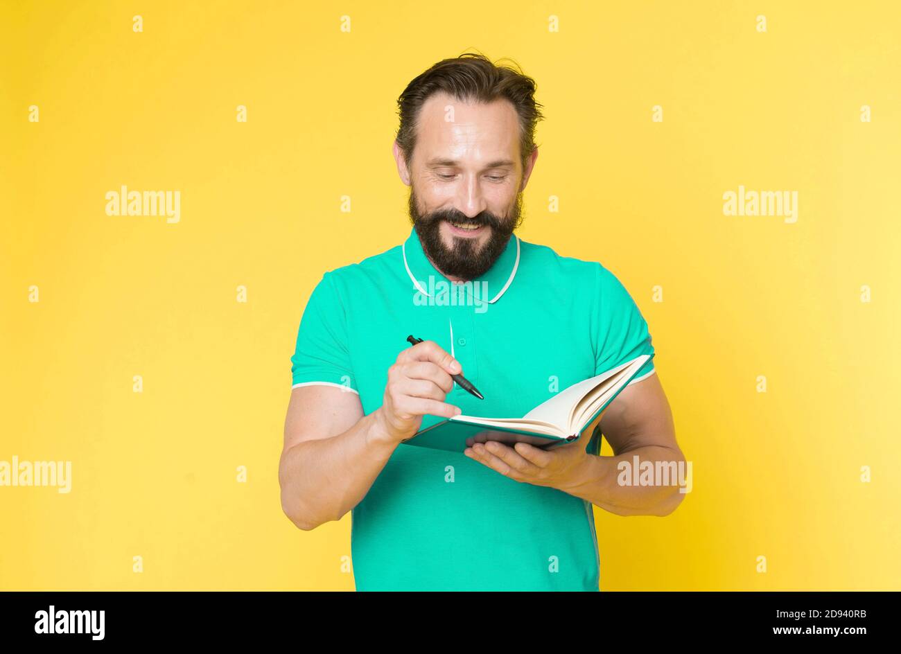 Helpful checklist. Man mature bearded guy writing notes to notepad ...