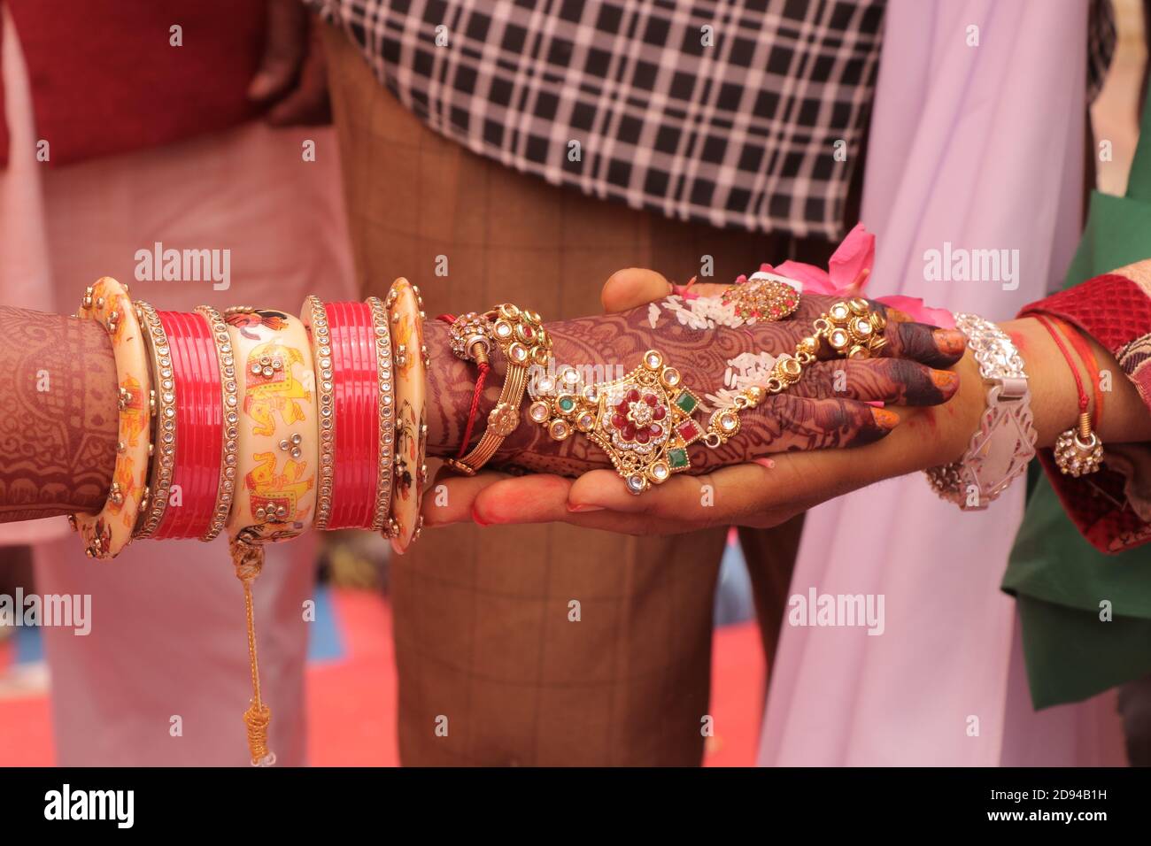 Bride's hand touching another woman's hand during an Indian marriage ...