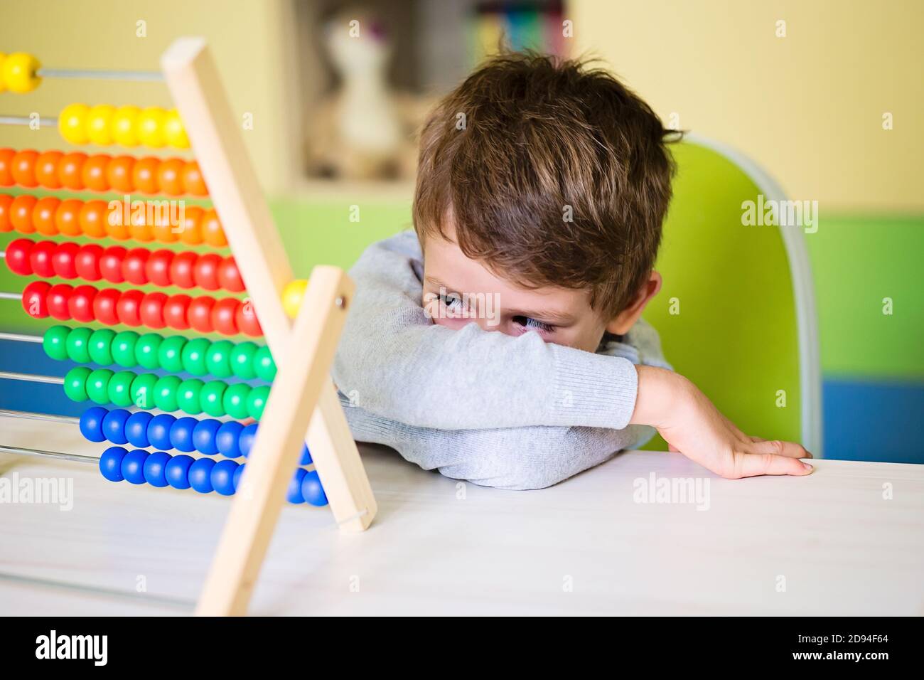 Sad Caucasian little boy refusing to play with an abacus Stock Photo ...