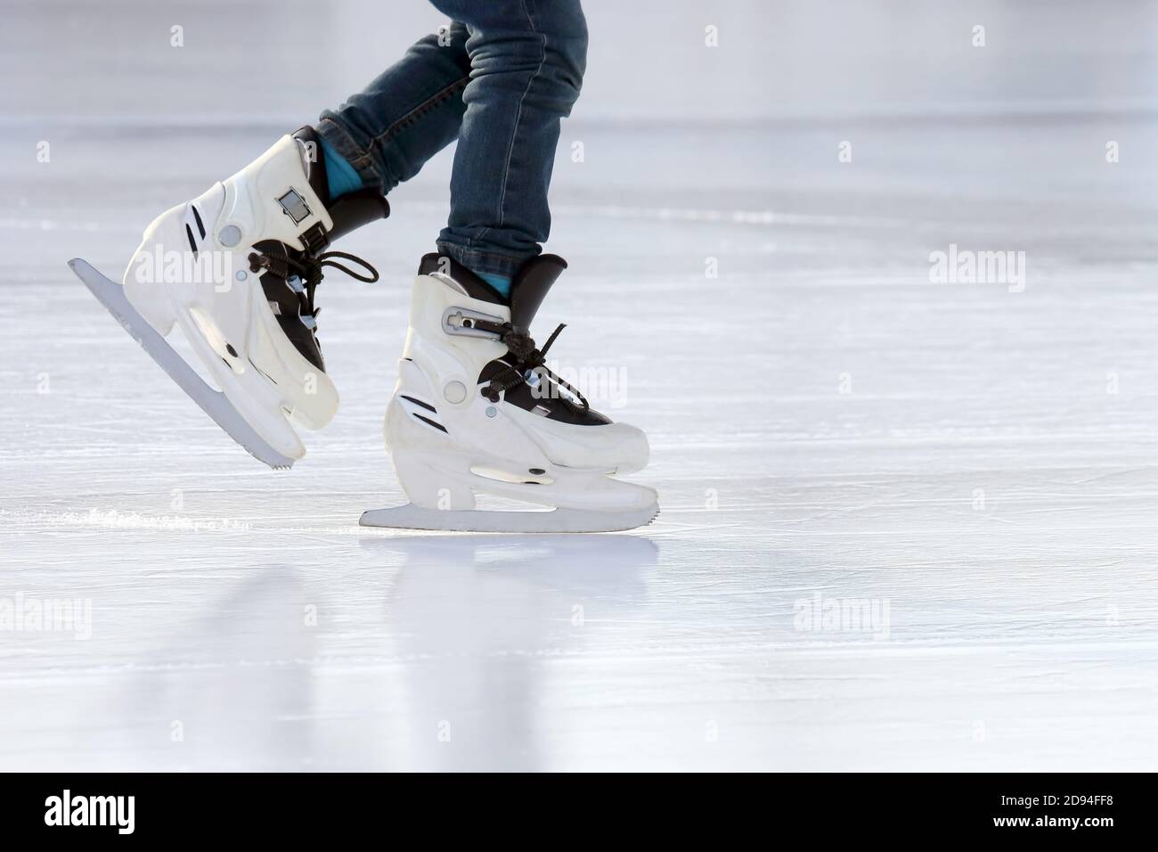 feet on the skates of a person rolling on the ice rink Stock Photo - Alamy