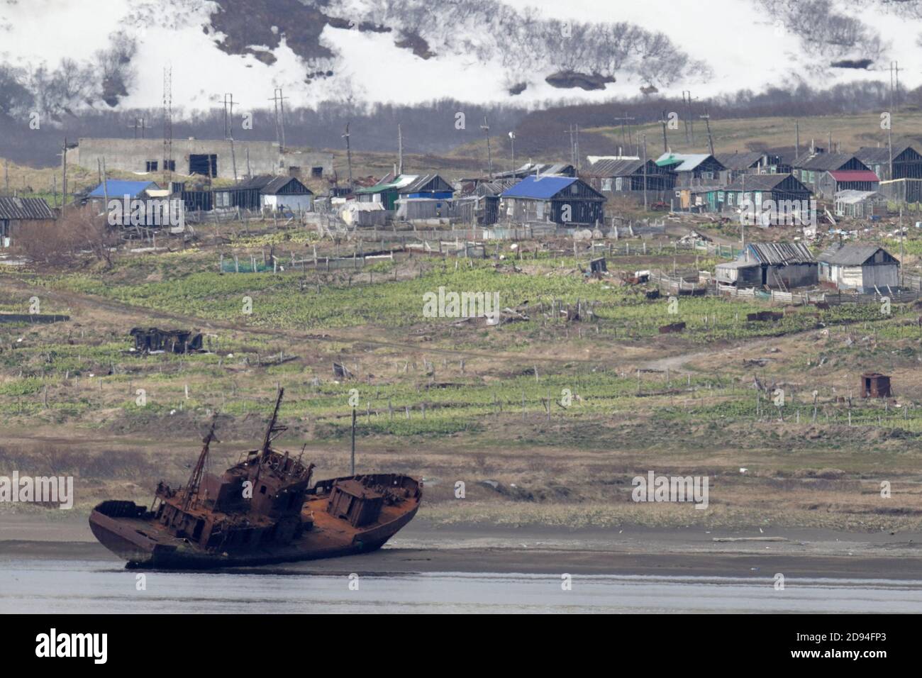 Rusting wrecked trawler, Severo Kurilsk, bleak coastline of Paramushir ...