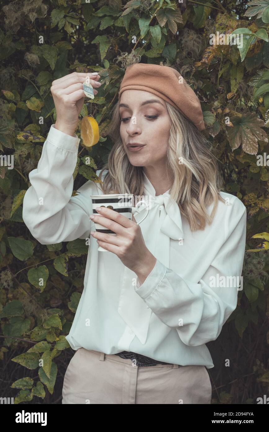 Young woman blowing air into hot cup of tea with lemon Stock Photo - Alamy