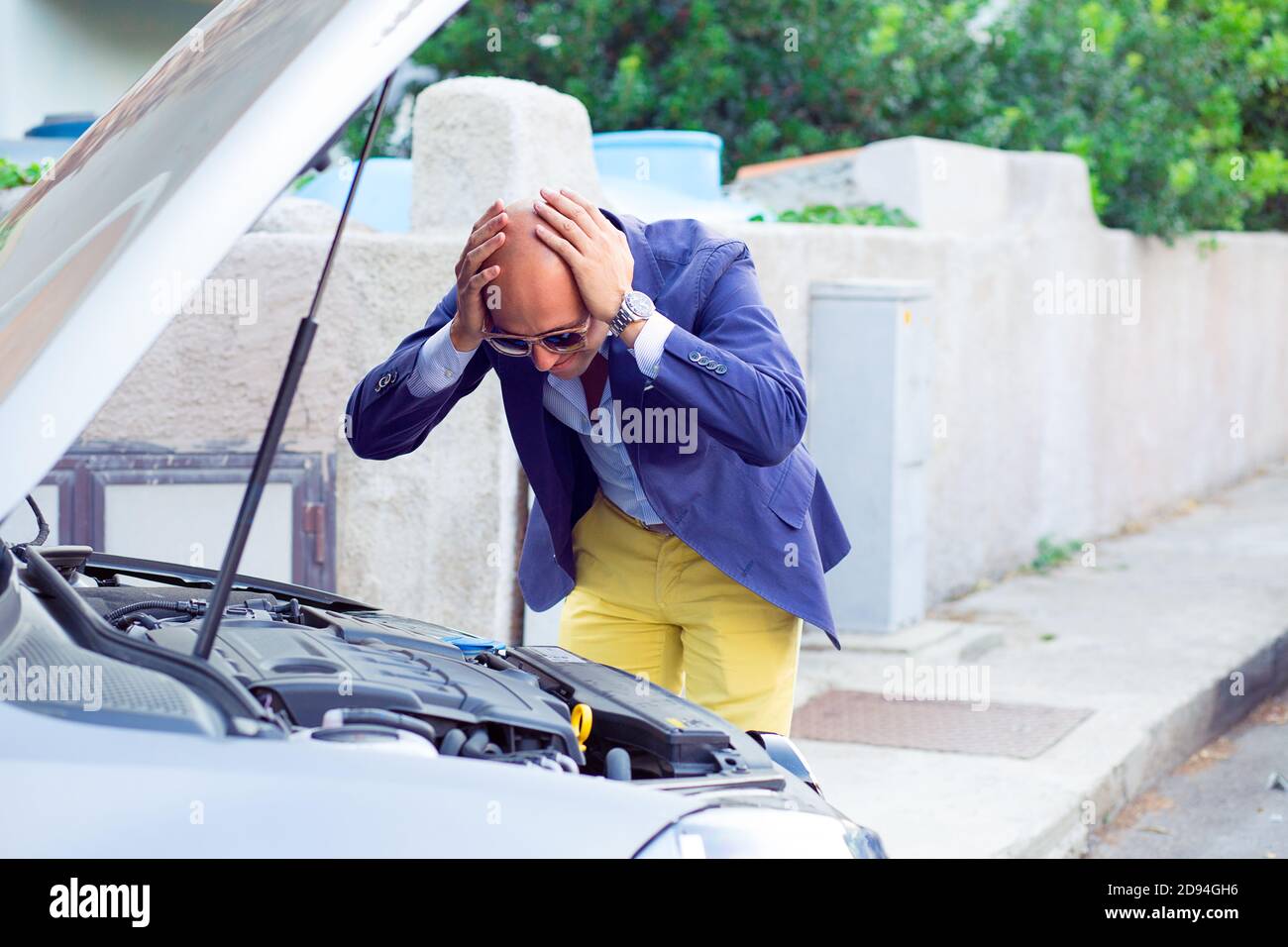 Stressed man having trouble with his broken car looking in frustration ...