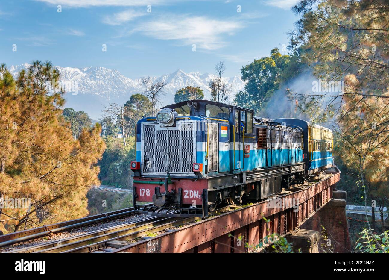 An approaching blue diesel train on railway tracks over a bridge in ...