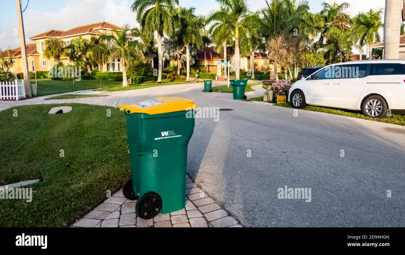 Green and yellow waste management garbage cans at the curb for trash ...